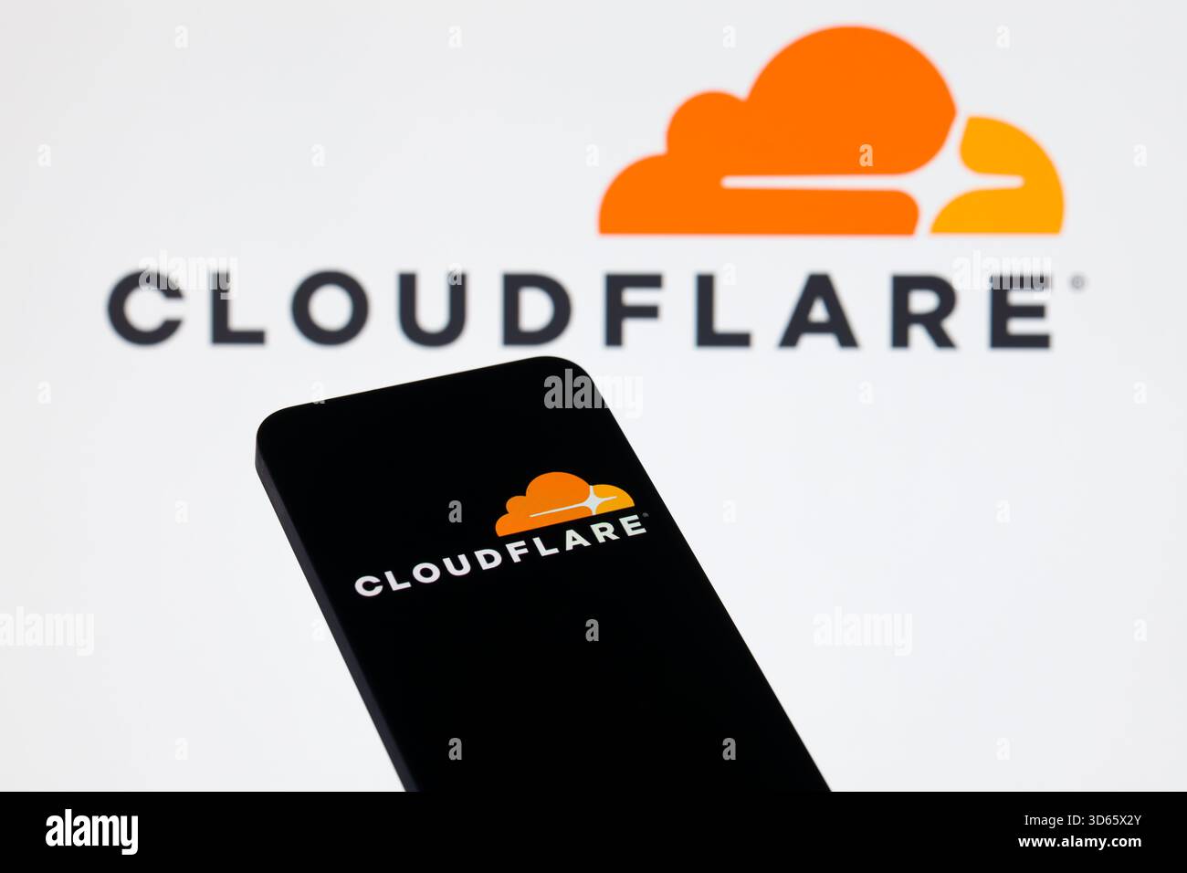 The Cloudflare logo is being displayed on a mobile phone with ...