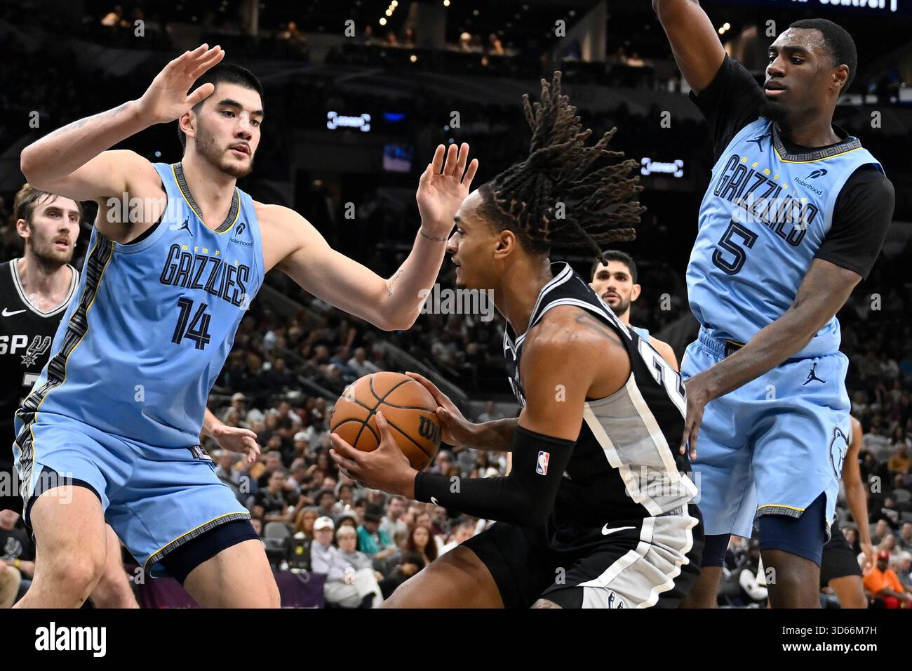 San Antonio Spurs guard Devin Vassell, center, drives against Memphis ...