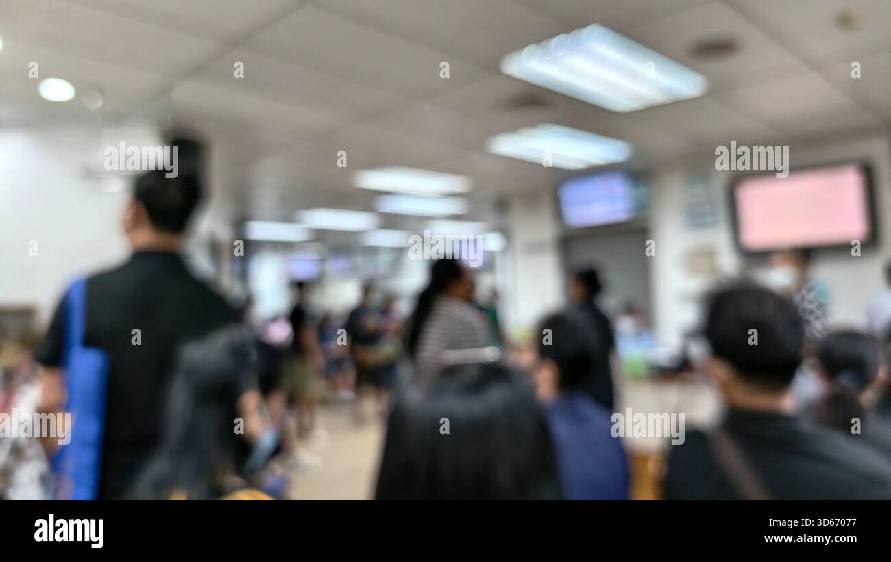 Blurred image depicting the interior of busy hospital waiting room or ...