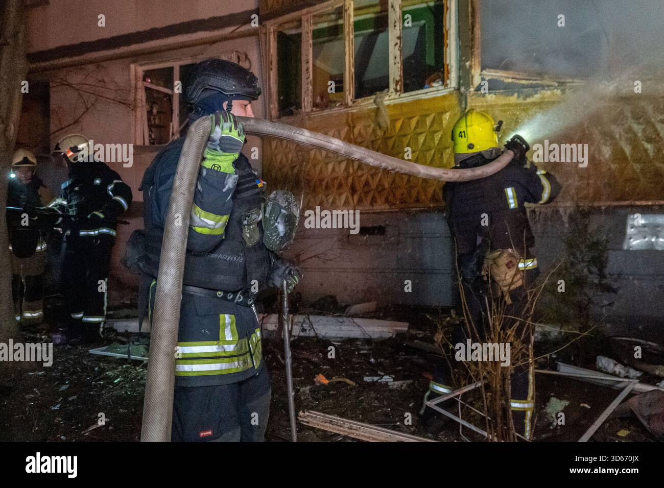 Rescue workers put out a fire of a residential building damaged by a ...
