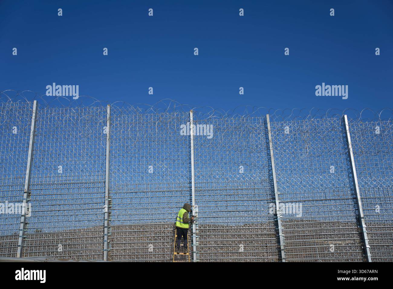 A construction worker builds the fence on the border with Lebanon, in ...