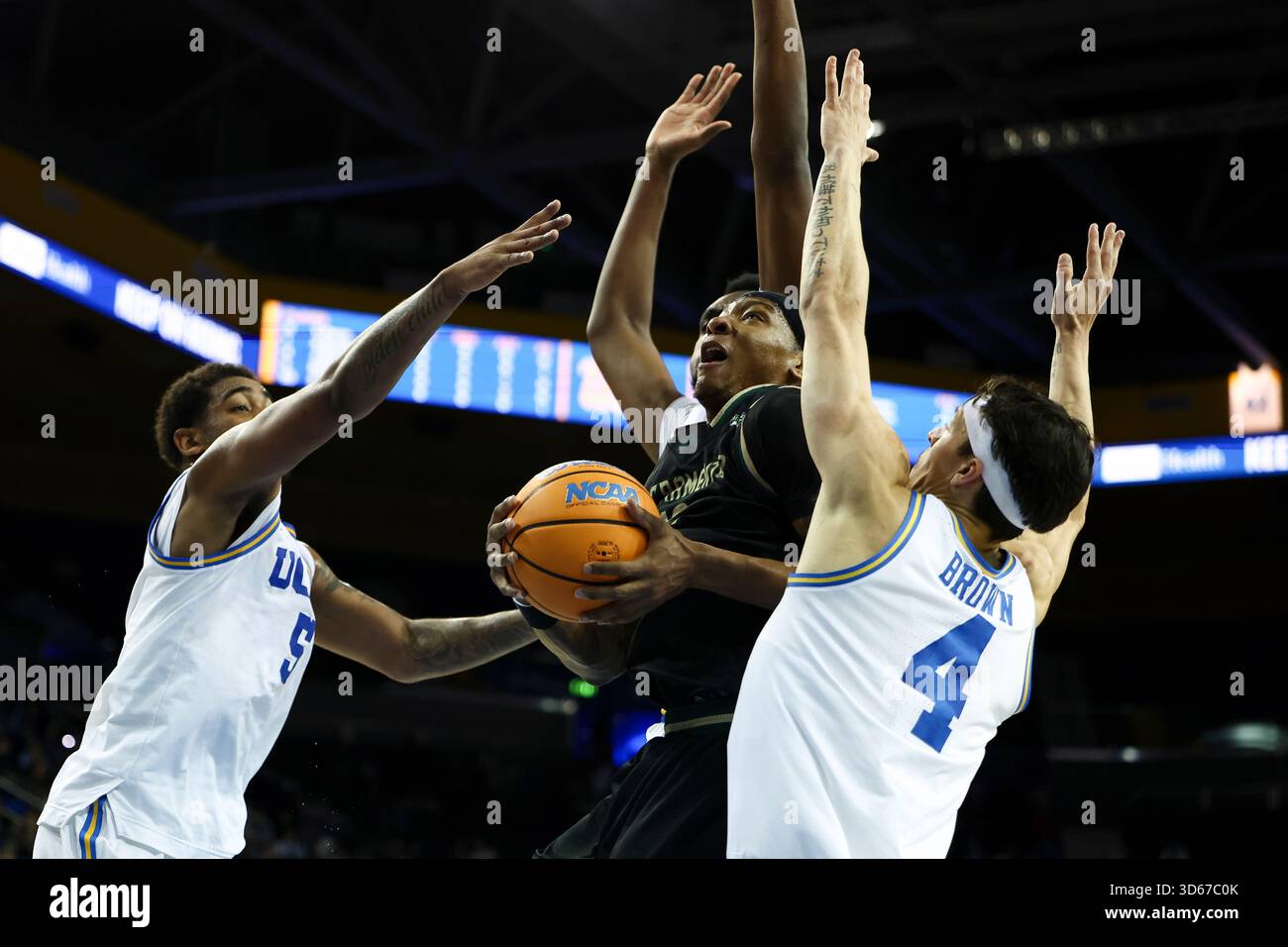 Sacramento State guard Prophet Johnson, center, drives to the basket against UCLA guard Brandon ...
