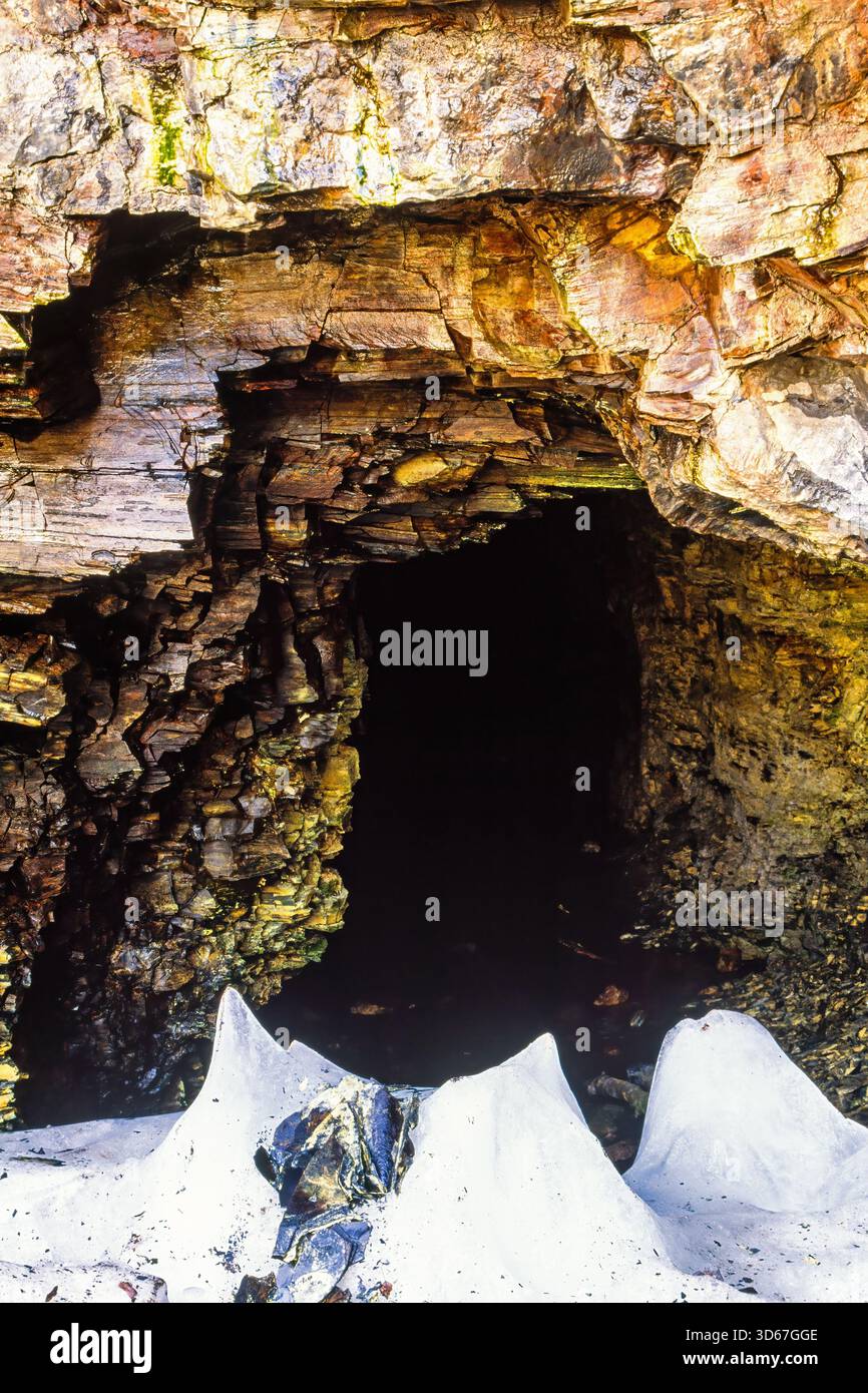 Entrance to an old abandoned mine shaft with snow and ice at the ...