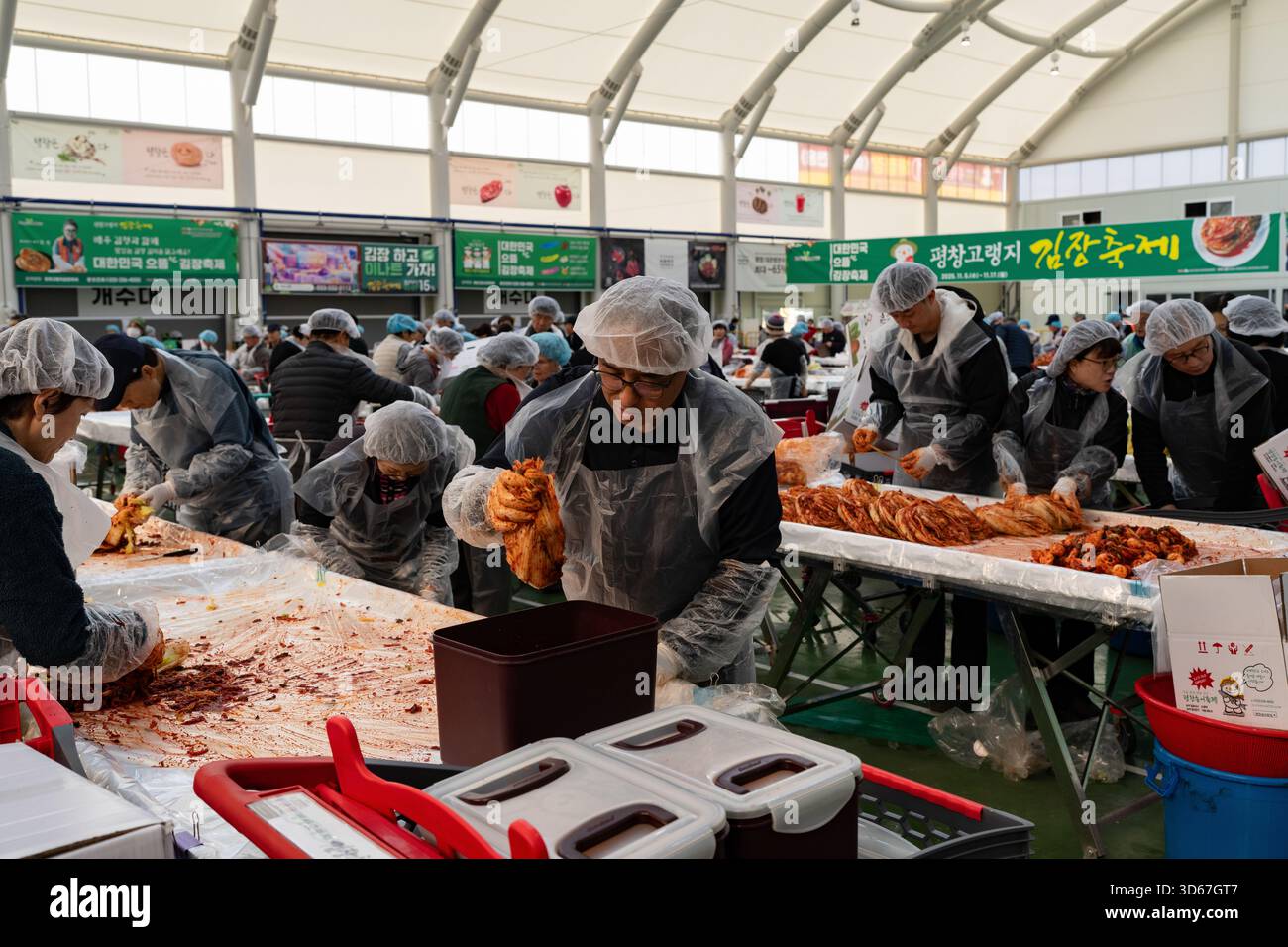 A participant places freshly made kimchi into a container at the 2025 ...