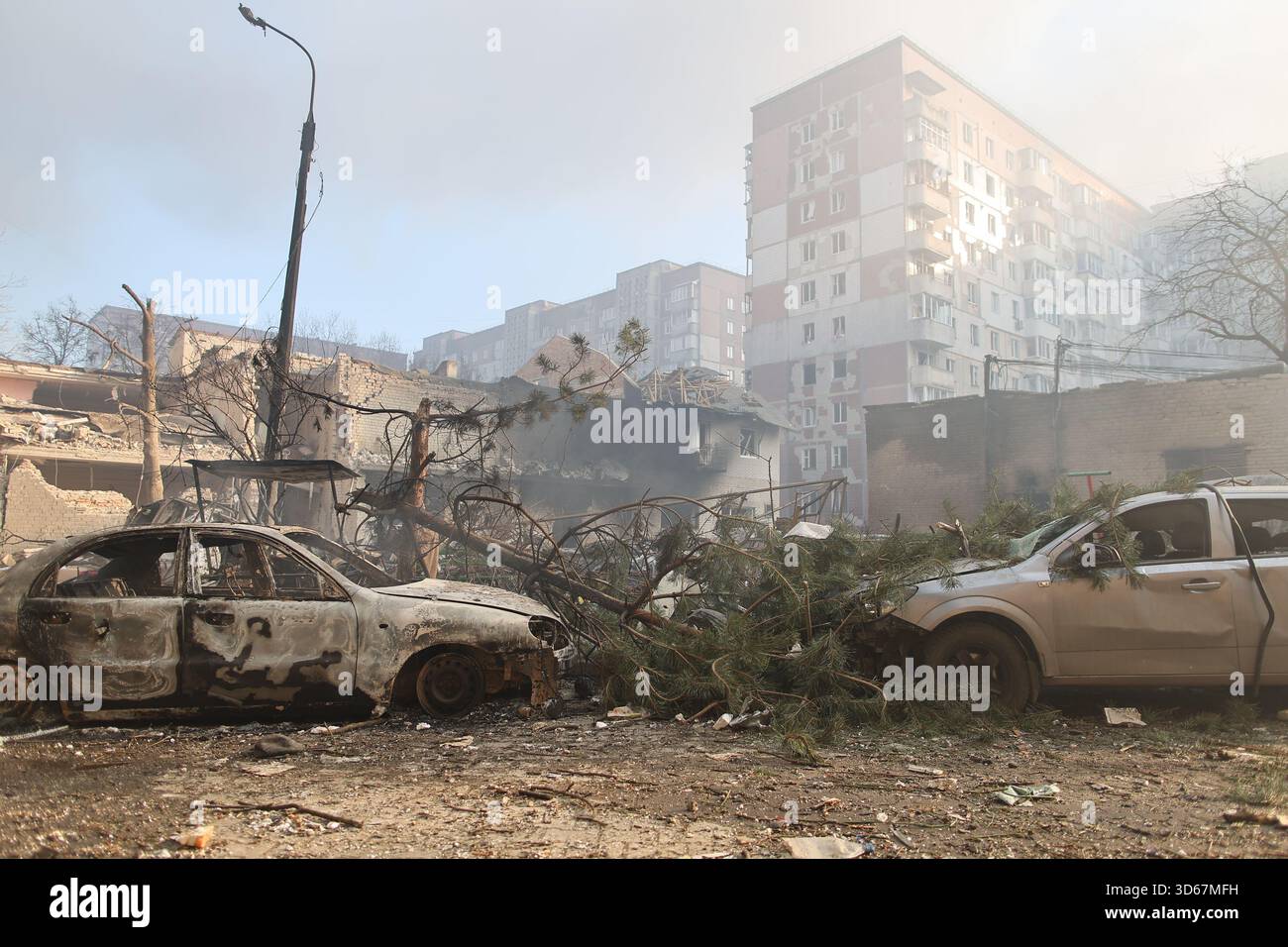 Burnt cars are seen in front of a residential building which was ...