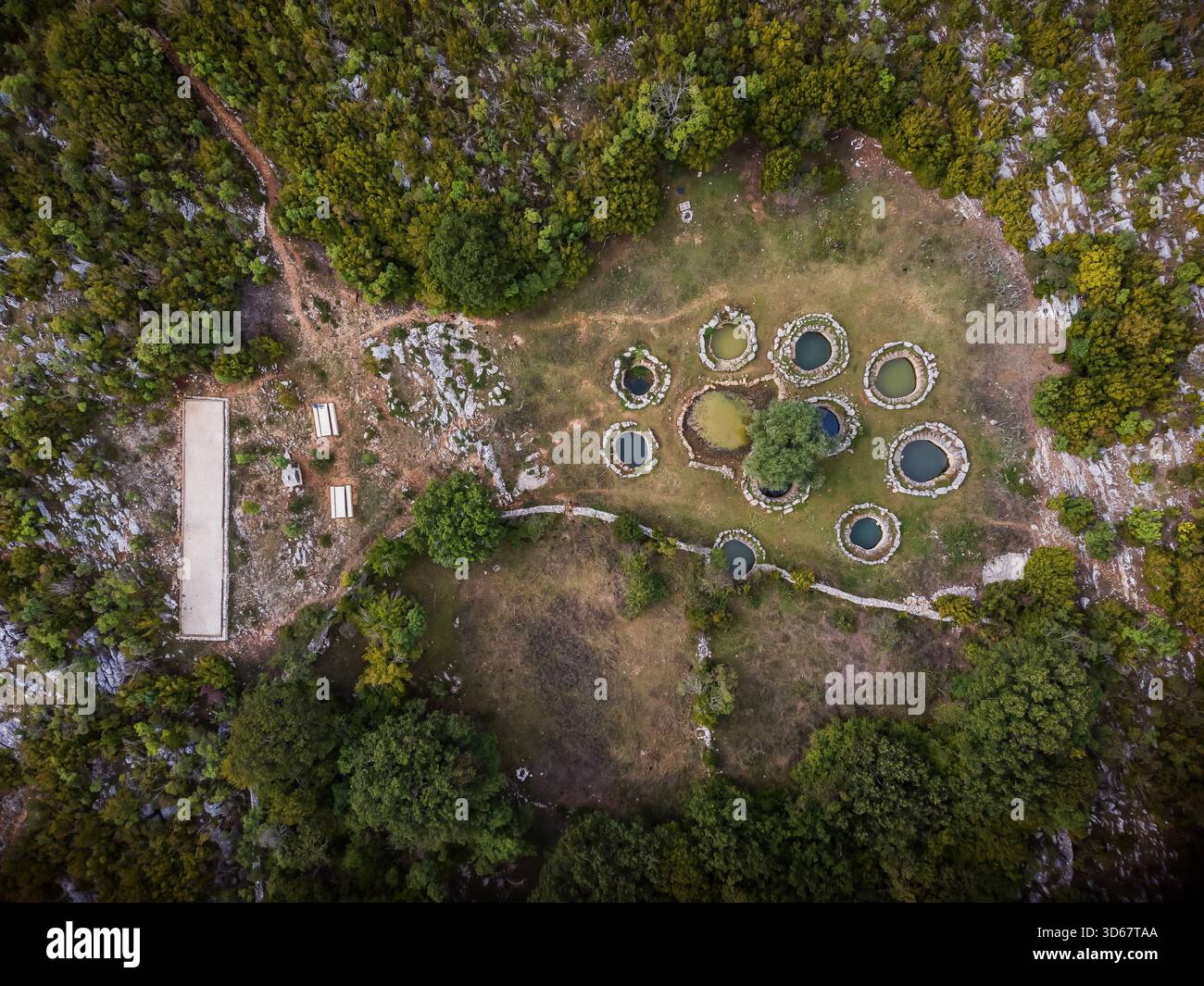 Aerial view of ancient stone wells clustered around a solitary tree ...