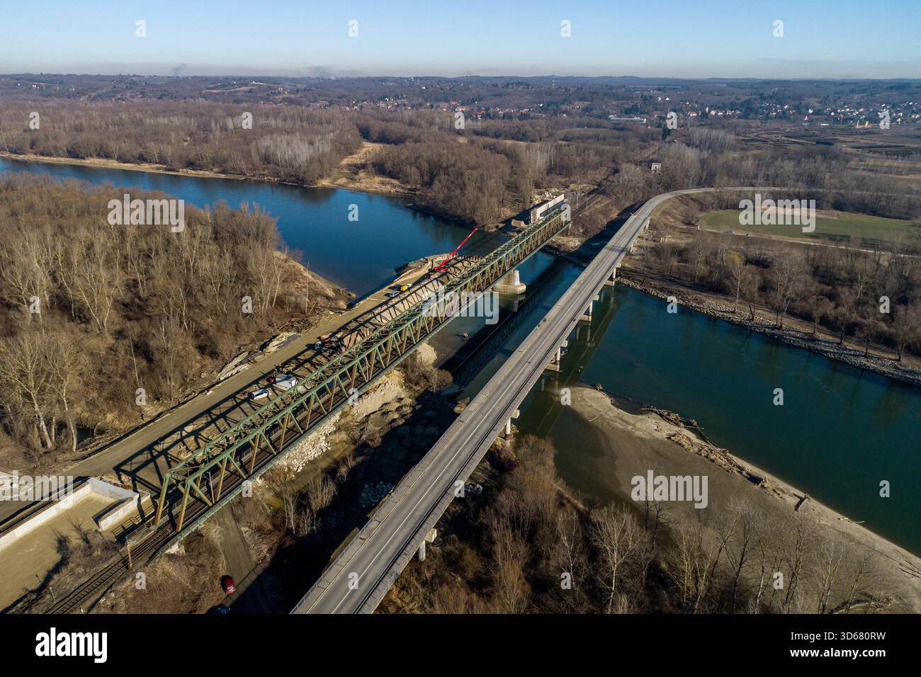 Aerial view of parallel bridges, one a green truss railway bridge and ...
