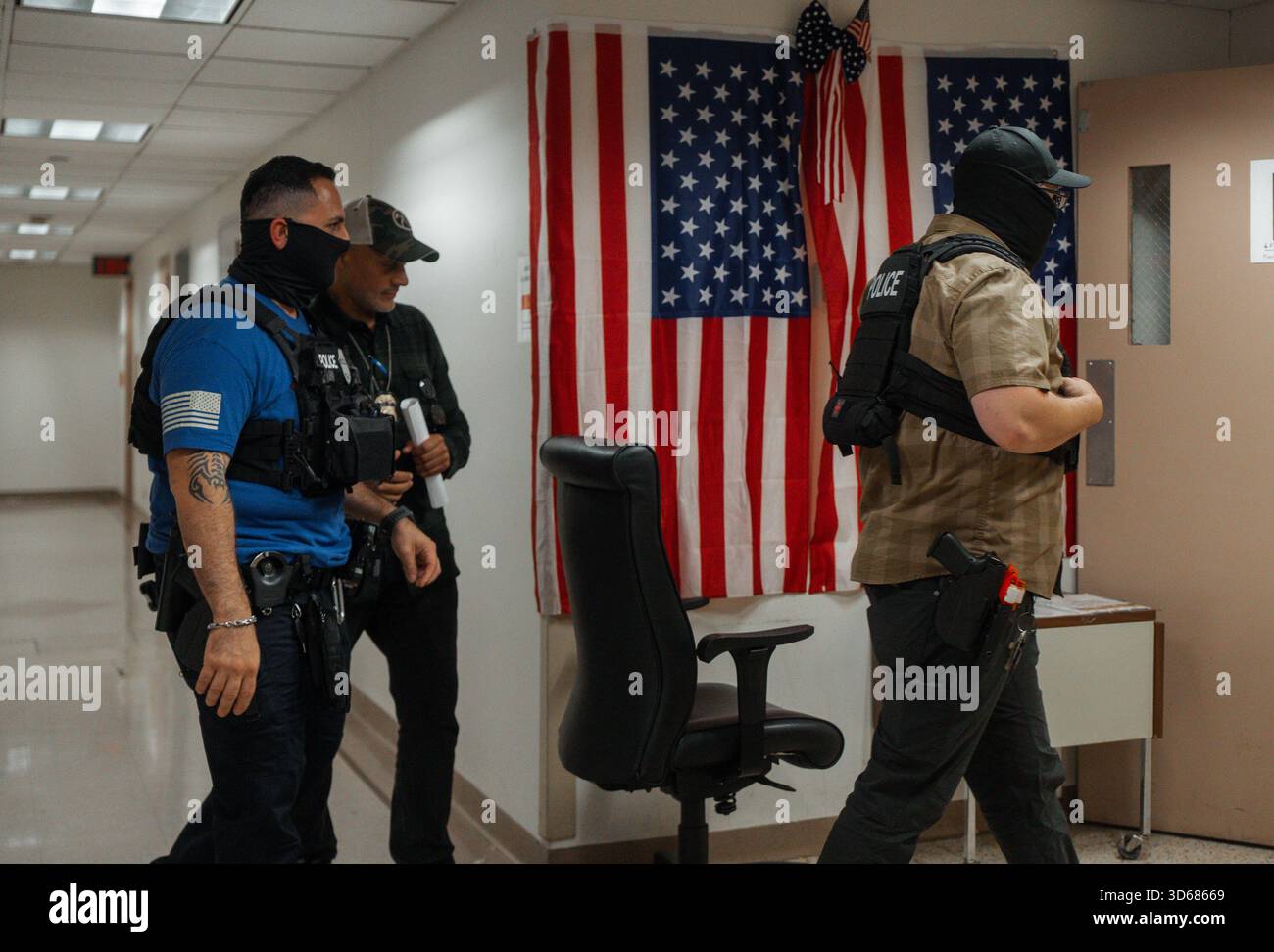 Immigration and Customs Enforcement agents walk through the hallways of ...