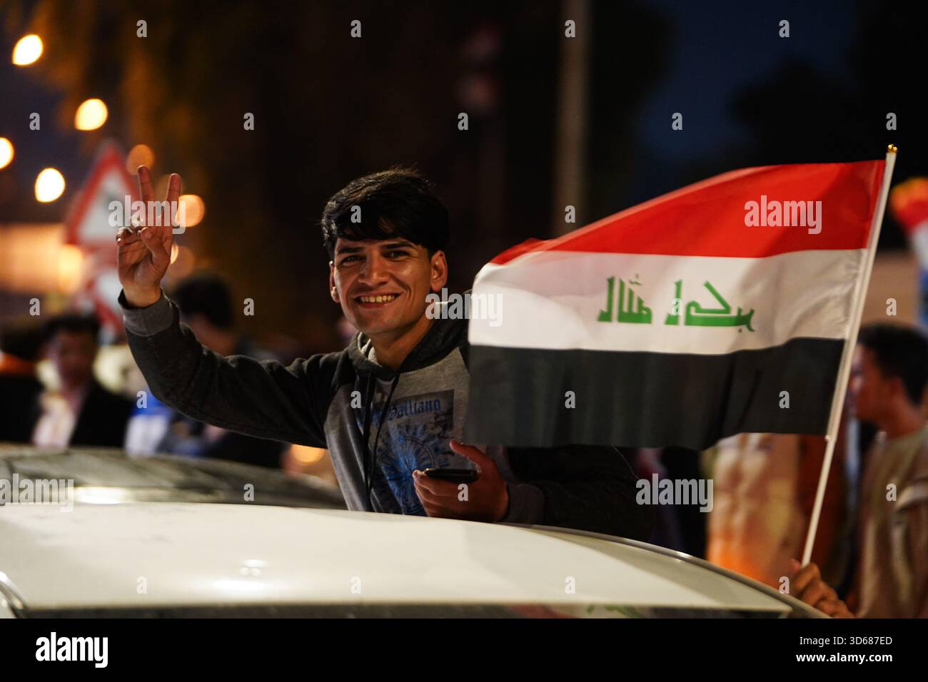 Iraqi young man waves flag as people celebrate following Iraq’s ...