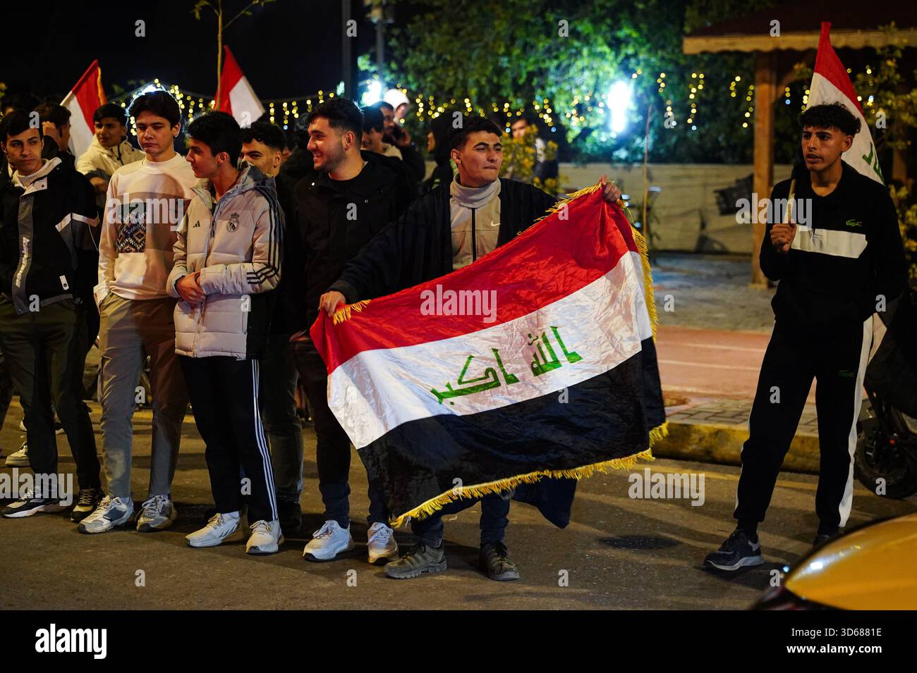 Iraqis wave flag as they celebrate following Iraq’s qualification to ...