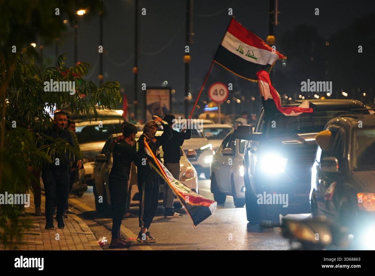 Iraqis wave flag as they celebrate following Iraq’s qualification to ...