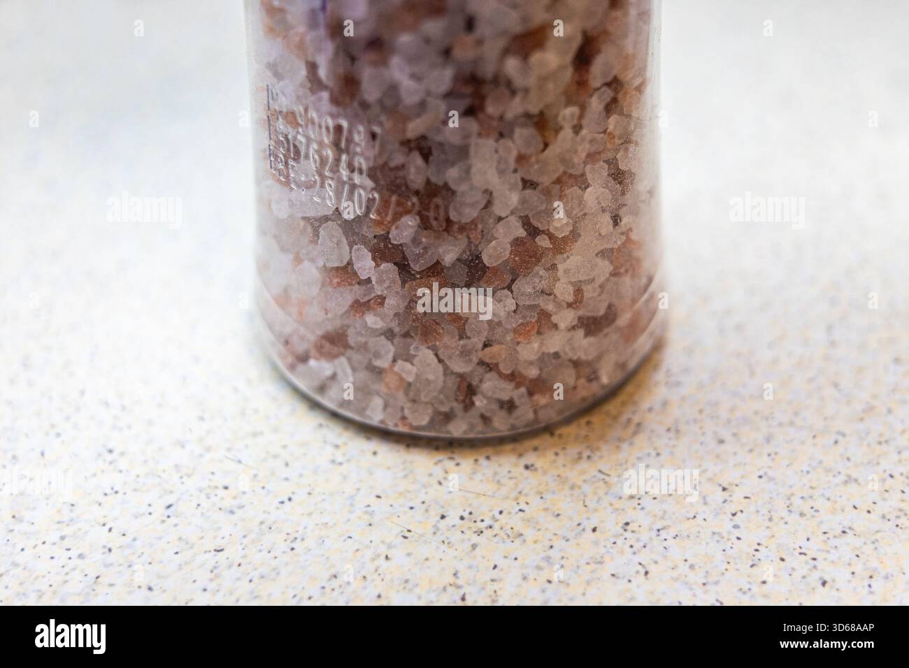 Chunky pink salt in a plastic bottle on a white table Stock Photo - Alamy