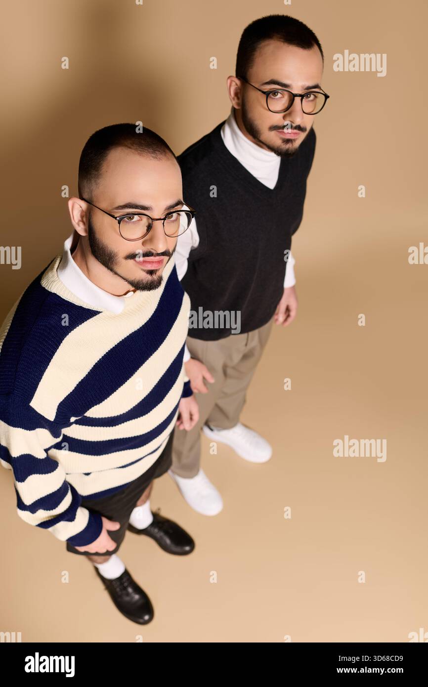 Two fashionable twin brothers stand side by side, sharing a striking ...