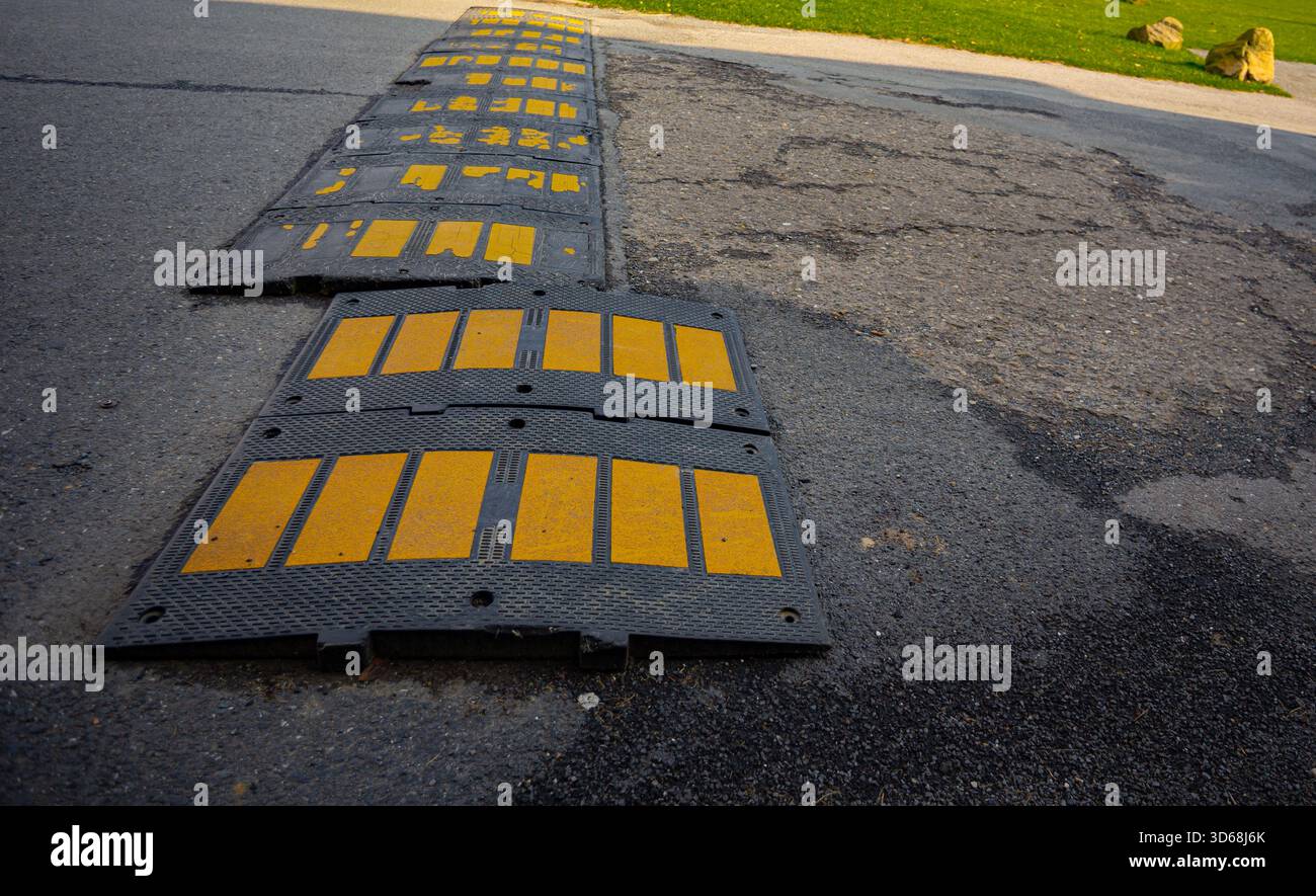 Speed hump on asphalt road - traffic calming device Stock Photo - Alamy