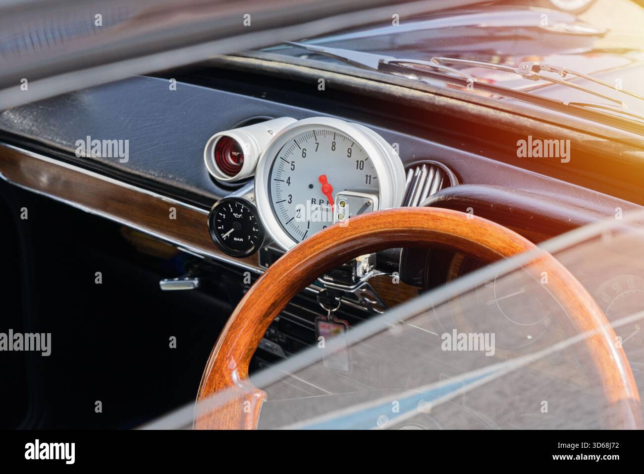Close view of vintage car dashboard with wooden steering wheel, large ...
