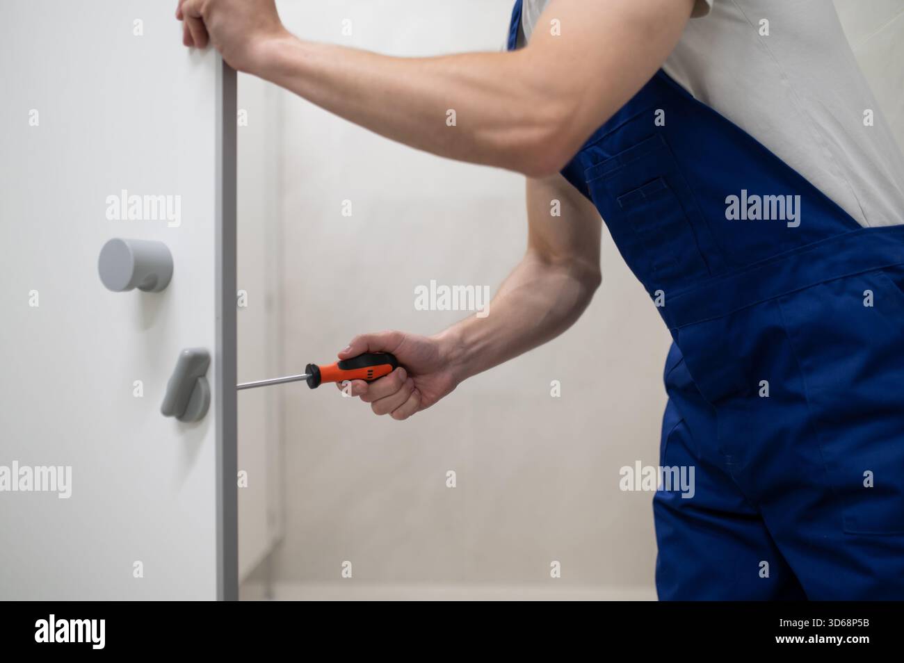 Maintenance worker fixing cubicle door handle using tools Stock Photo ...