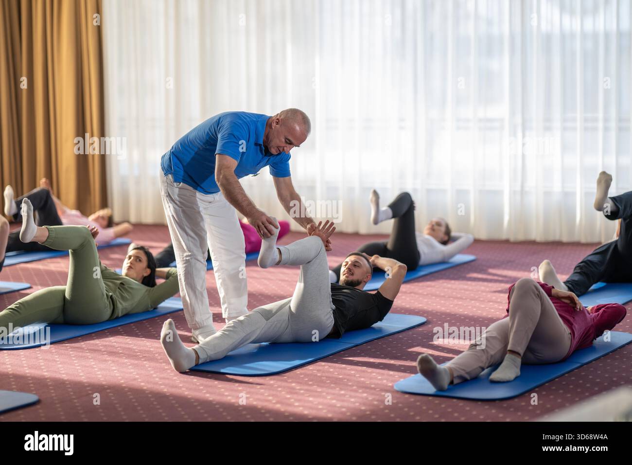 Instructor leading a diverse group of people during a fitness training ...
