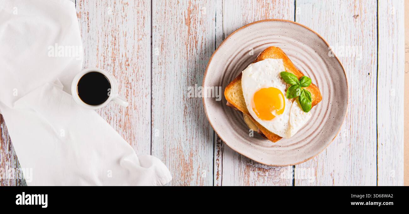 French croque madame hot breakfast sandwich on a plate on the table top ...