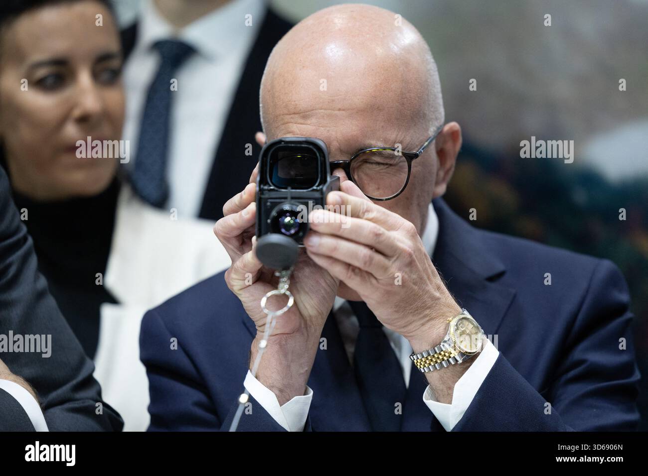 President of UDR parliamentary group Eric Ciotti looks through an optic on the Safran booth ...