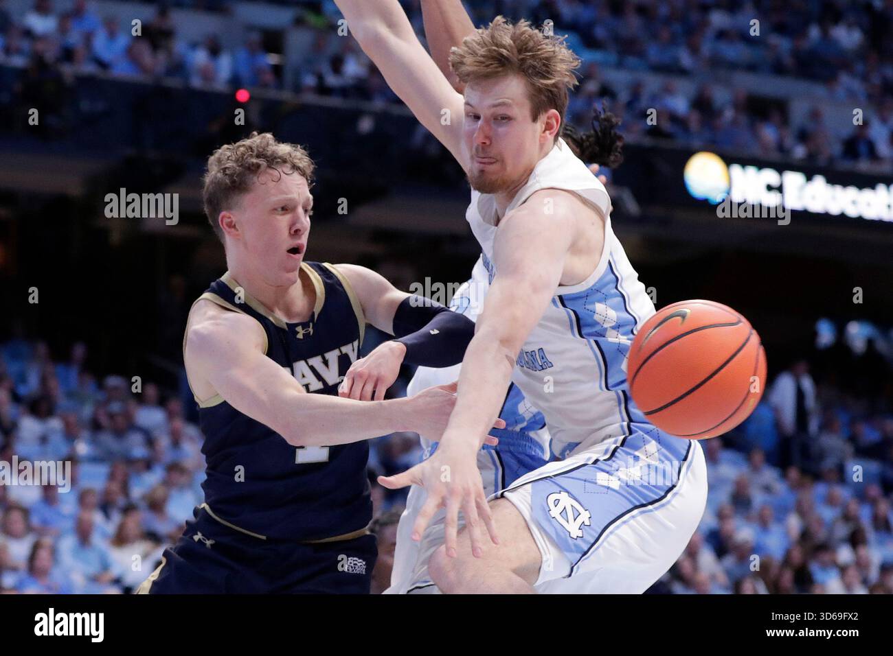 Navy guard Austin Benigni, left, passes around North Carolina center ...