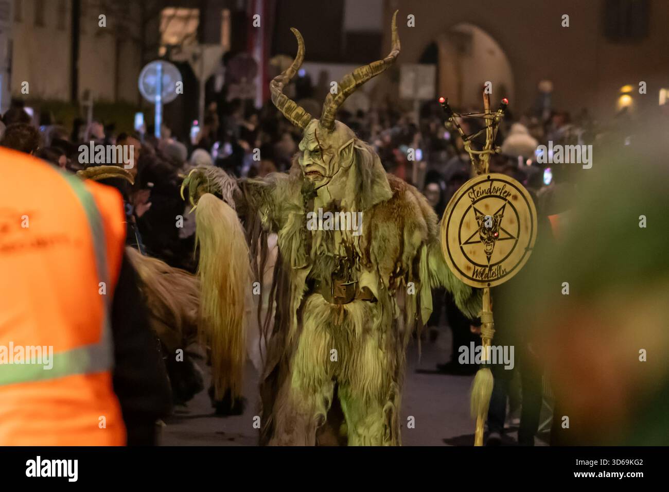 Krampus in a massive costume walks down the street during a festive ...