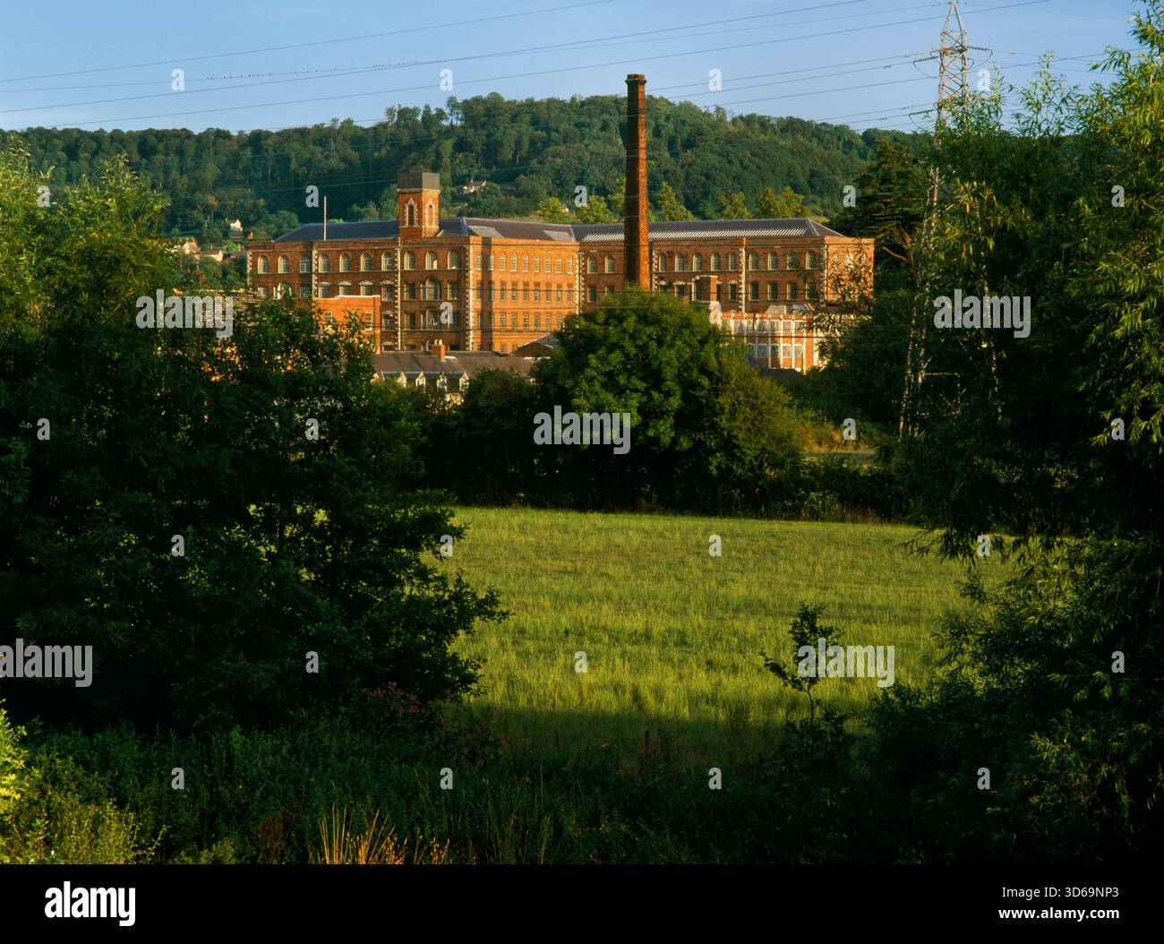 View SSE across water meadows to the complex of woollen mill buildings ...