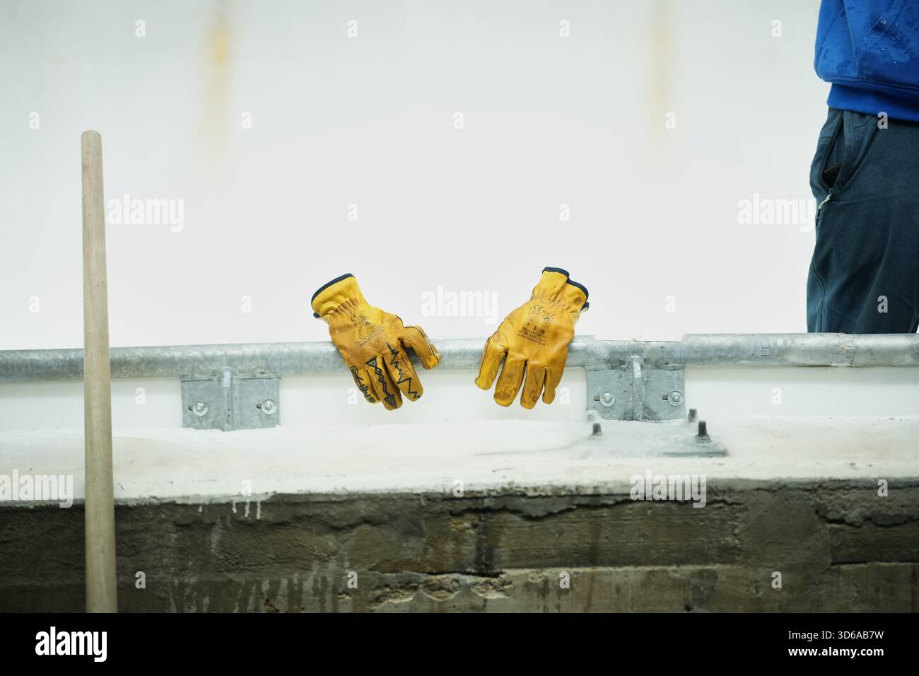 A worker's gloves and tool are lined up along the track ahead of a ...