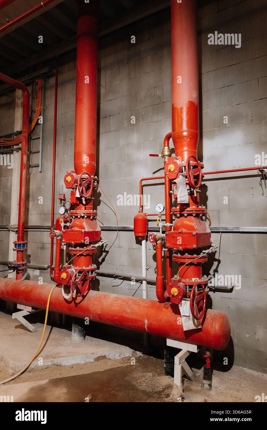 Fire sprinkler valves and red pipes in industrial plant, safety ...