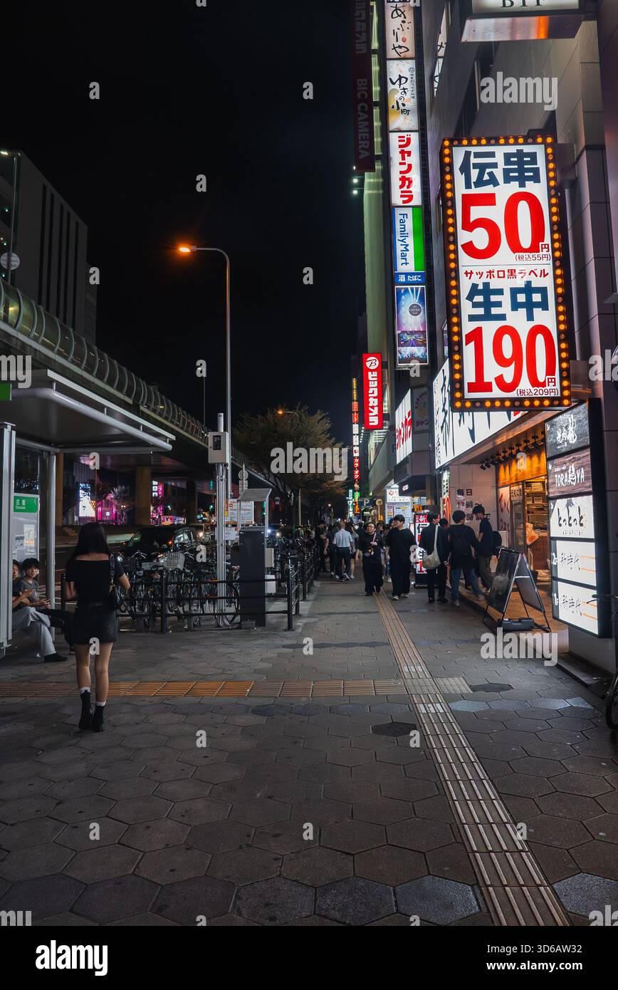 Night street in Osaka with neon signs, eateries, and bicycles Stock ...