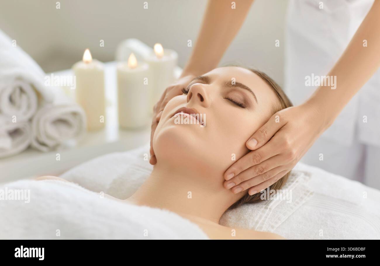 Massaging woman face, female client lying relaxing with eyes closed in ...