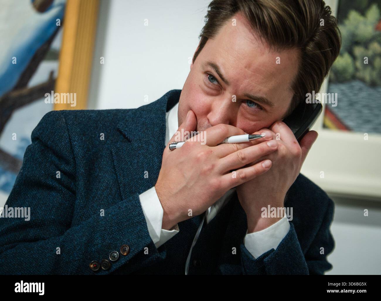 A person speaks on the phone during bidding in an auction for works of ...