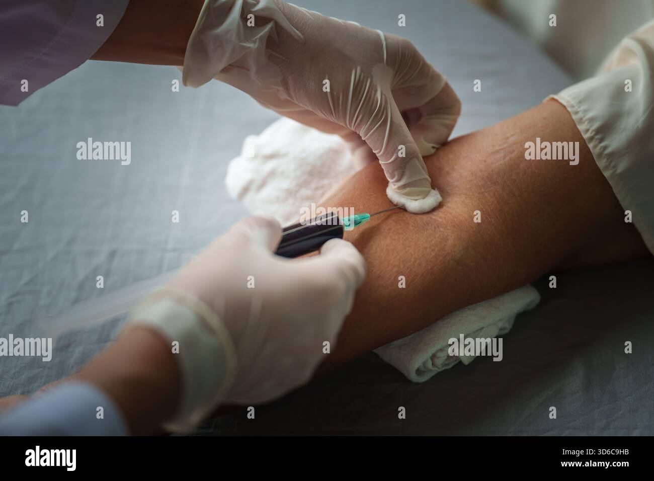 close up of doctor or nurse taking a blood sample from arm vein with a ...