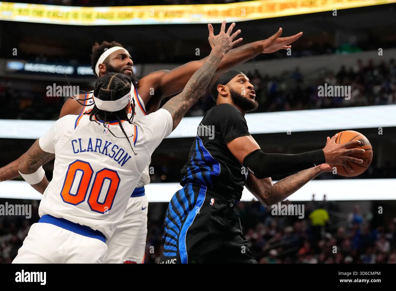 Dallas Mavericks forward Daniel Gafford drives past New York Knicks defenders Mitchell Robinson ...