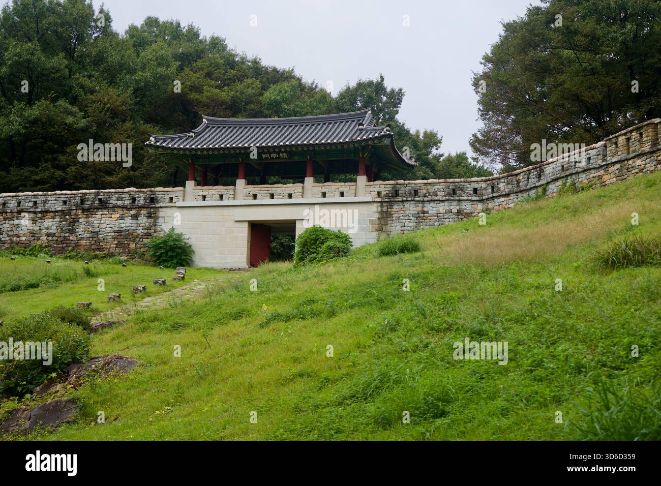 A tiled-roof gate pavilion stands atop the stone ramparts at the ...