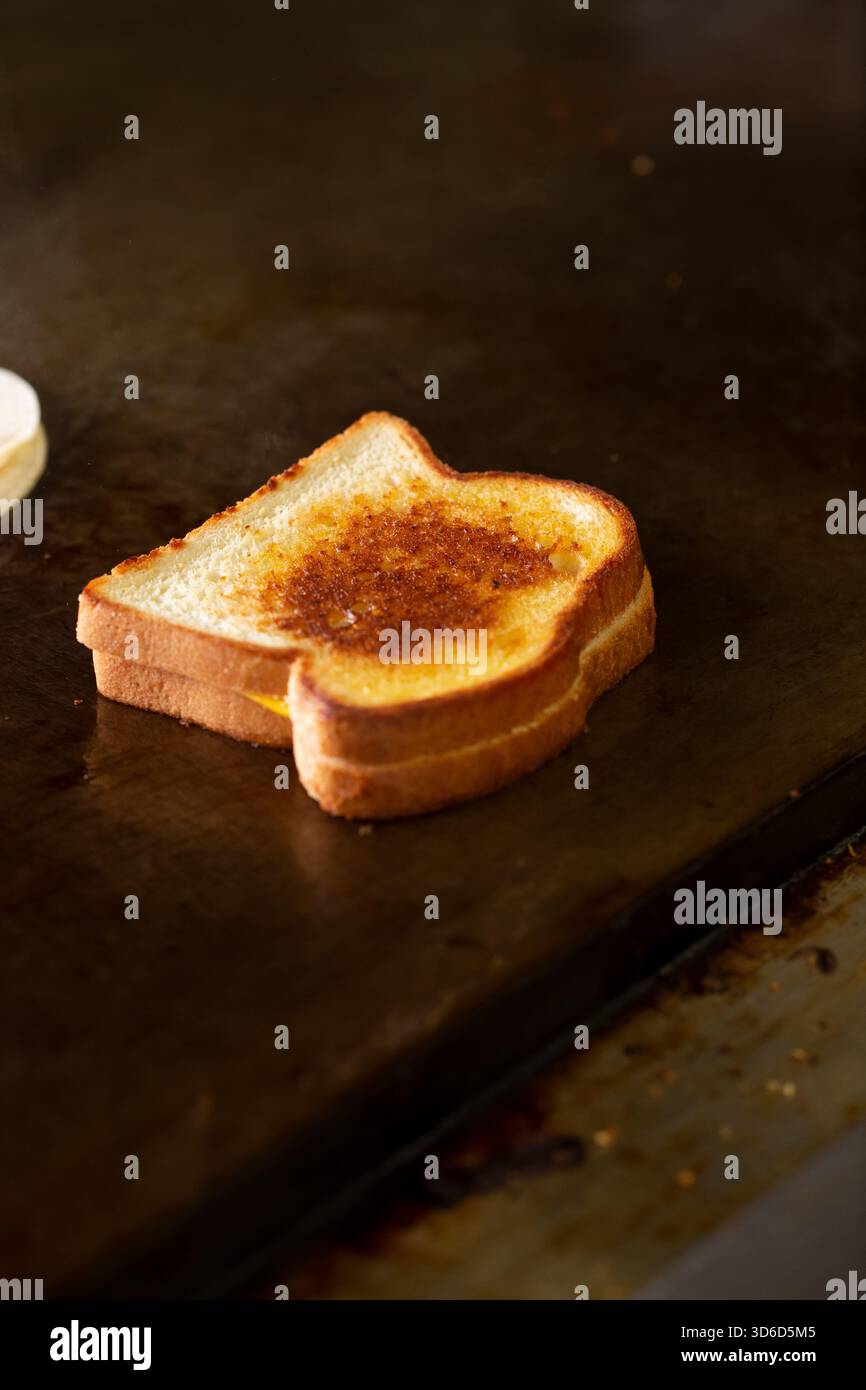 A view of a grilled cheese sandwich prepared on a griddle Stock Photo ...