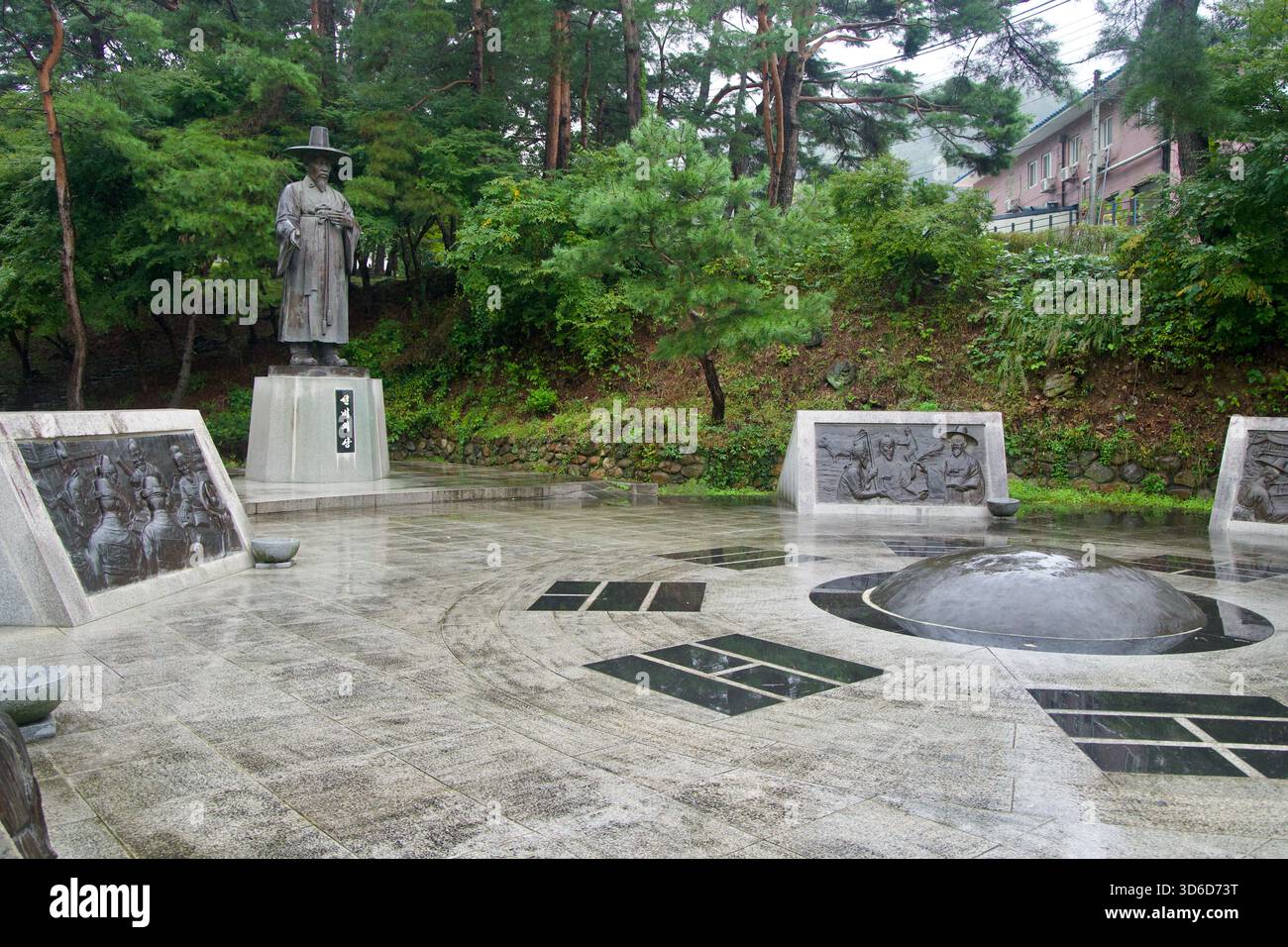 A bronze scholar statue overlooks a memorial plaza with engraved ...
