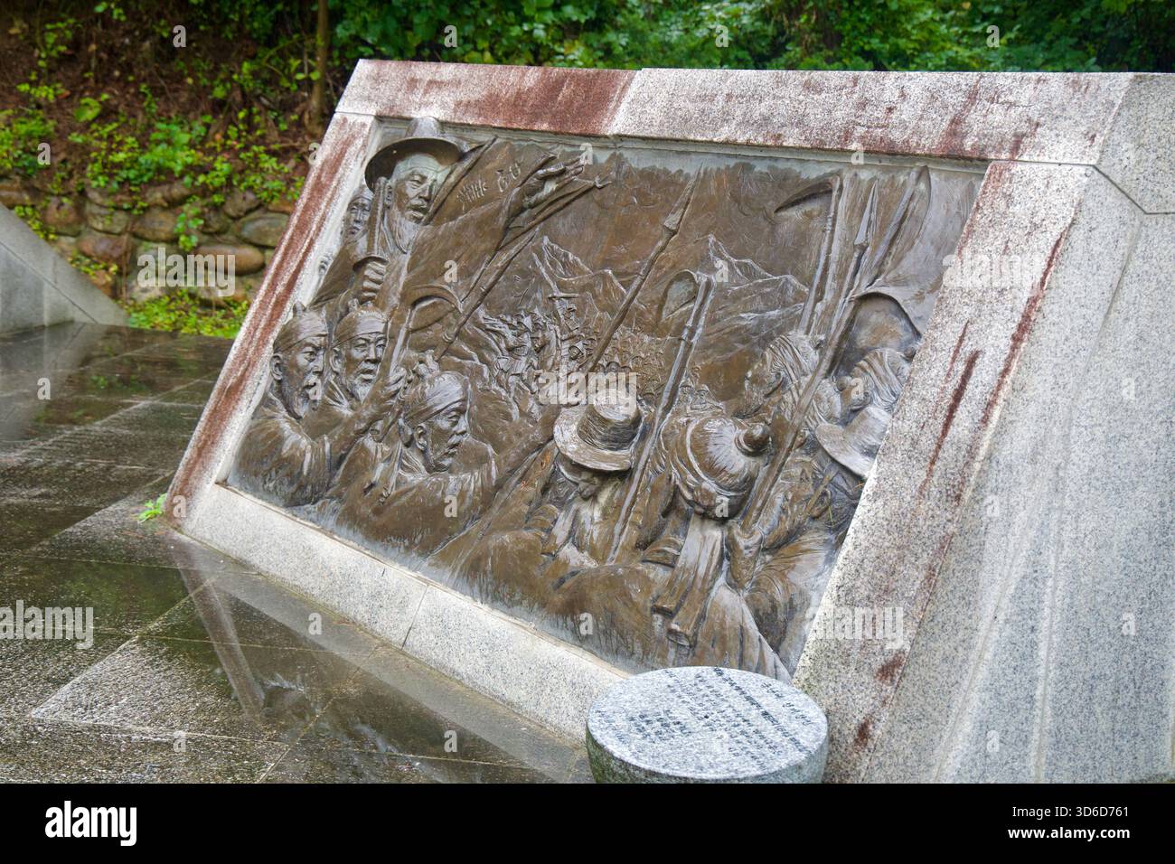 A bronze relief panel shows historic figures and banners in high relief ...