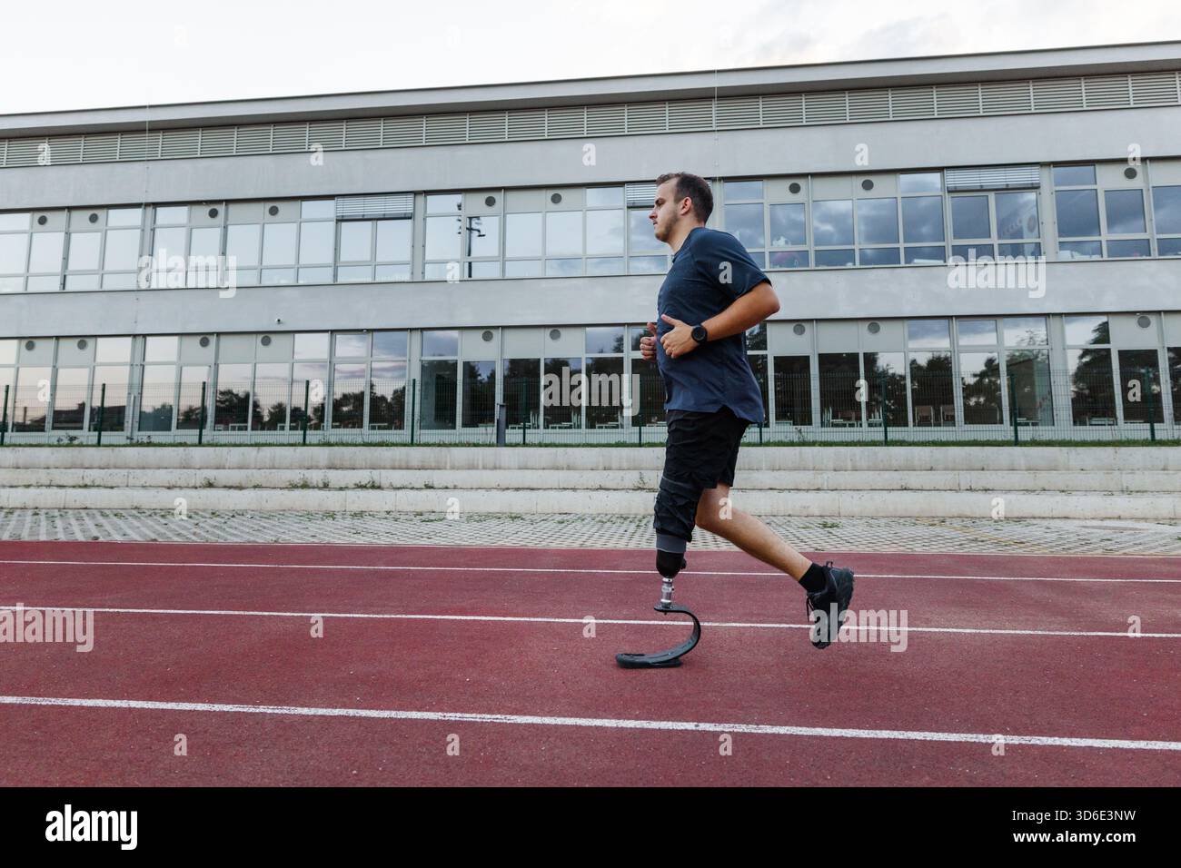 Man with a disability running on the athletic track wearing a ...