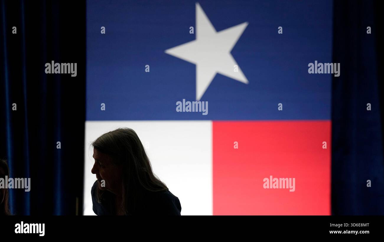 A woman silhouetted against a Texas flag before California Gov. Gavin ...