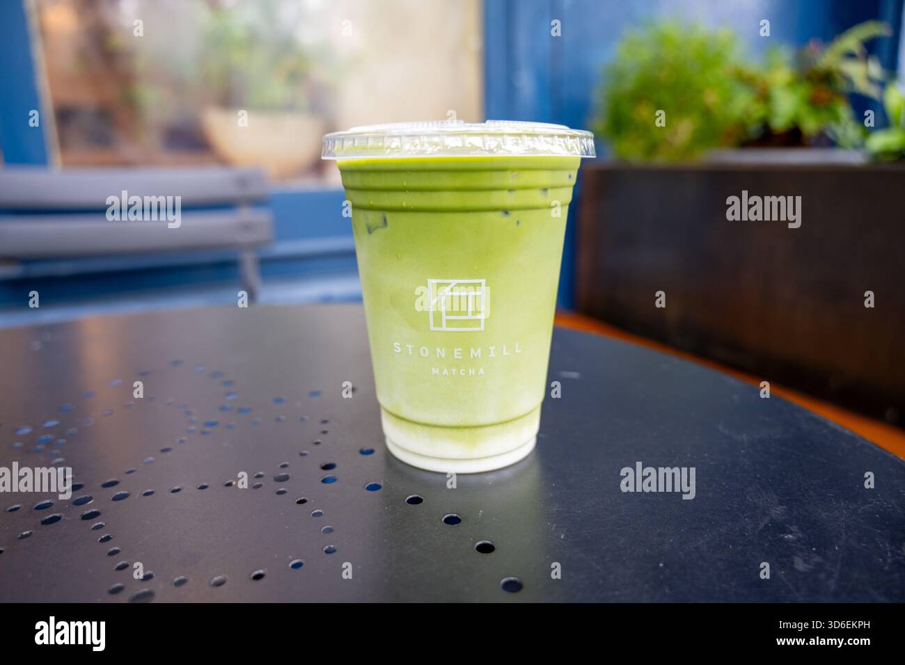 Close-up of iced matcha latte in a plastic to-go cup with Stonemill ...
