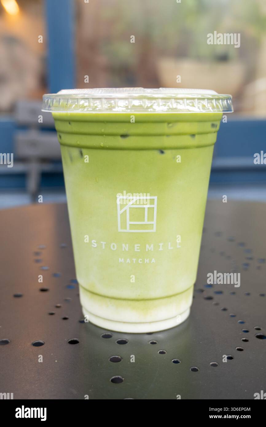 Close-up of iced matcha latte in a plastic to-go cup with Stonemill ...