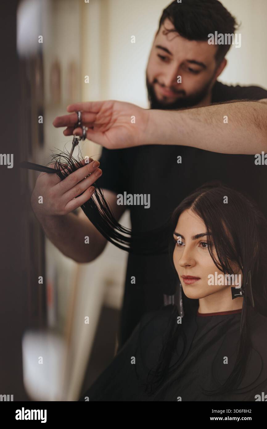 Hairdresser trims dark female hair hi-res stock photography and images ...