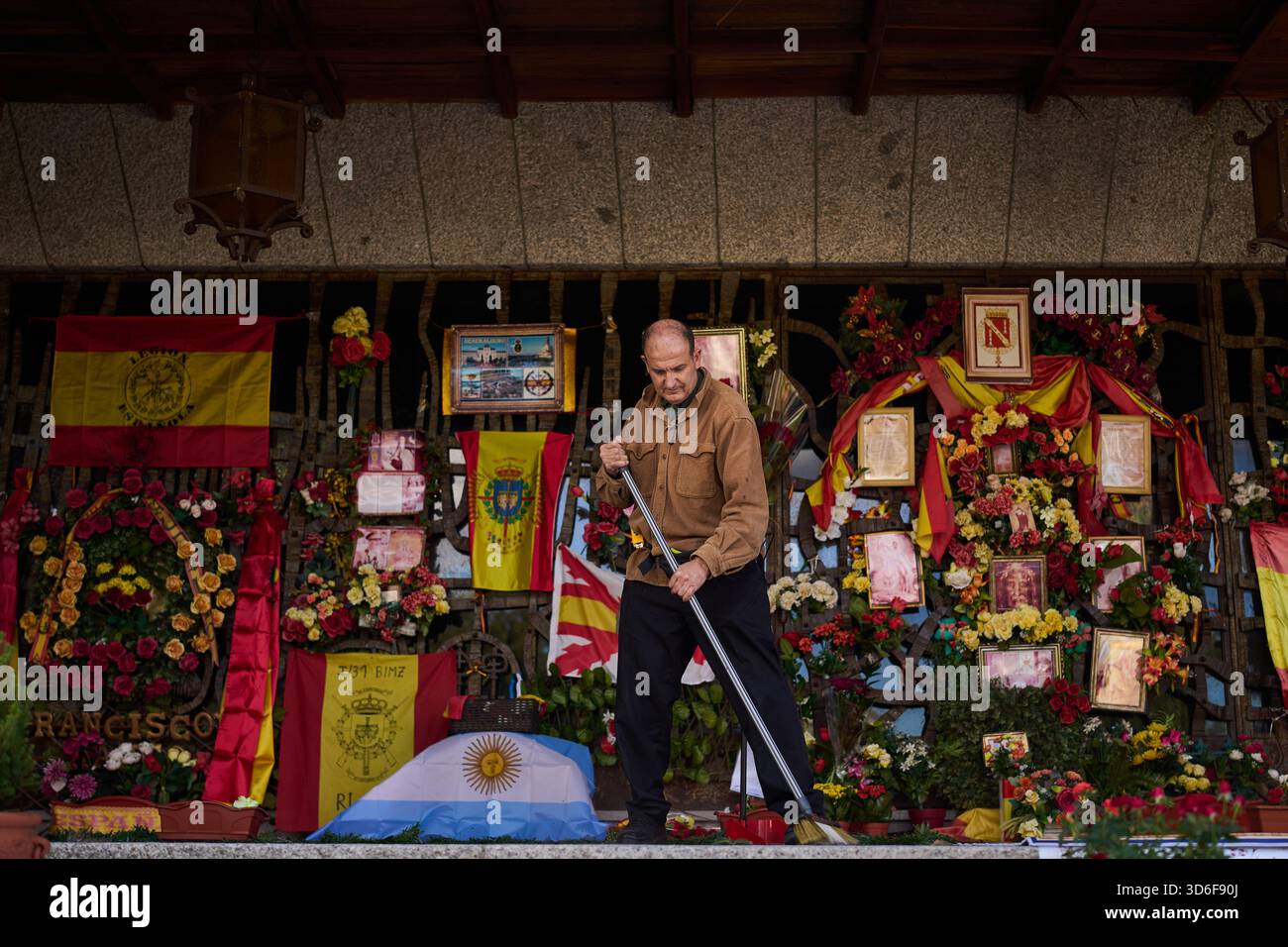 A man cleans the entrance to the mausoleum where Francisco Franco is ...