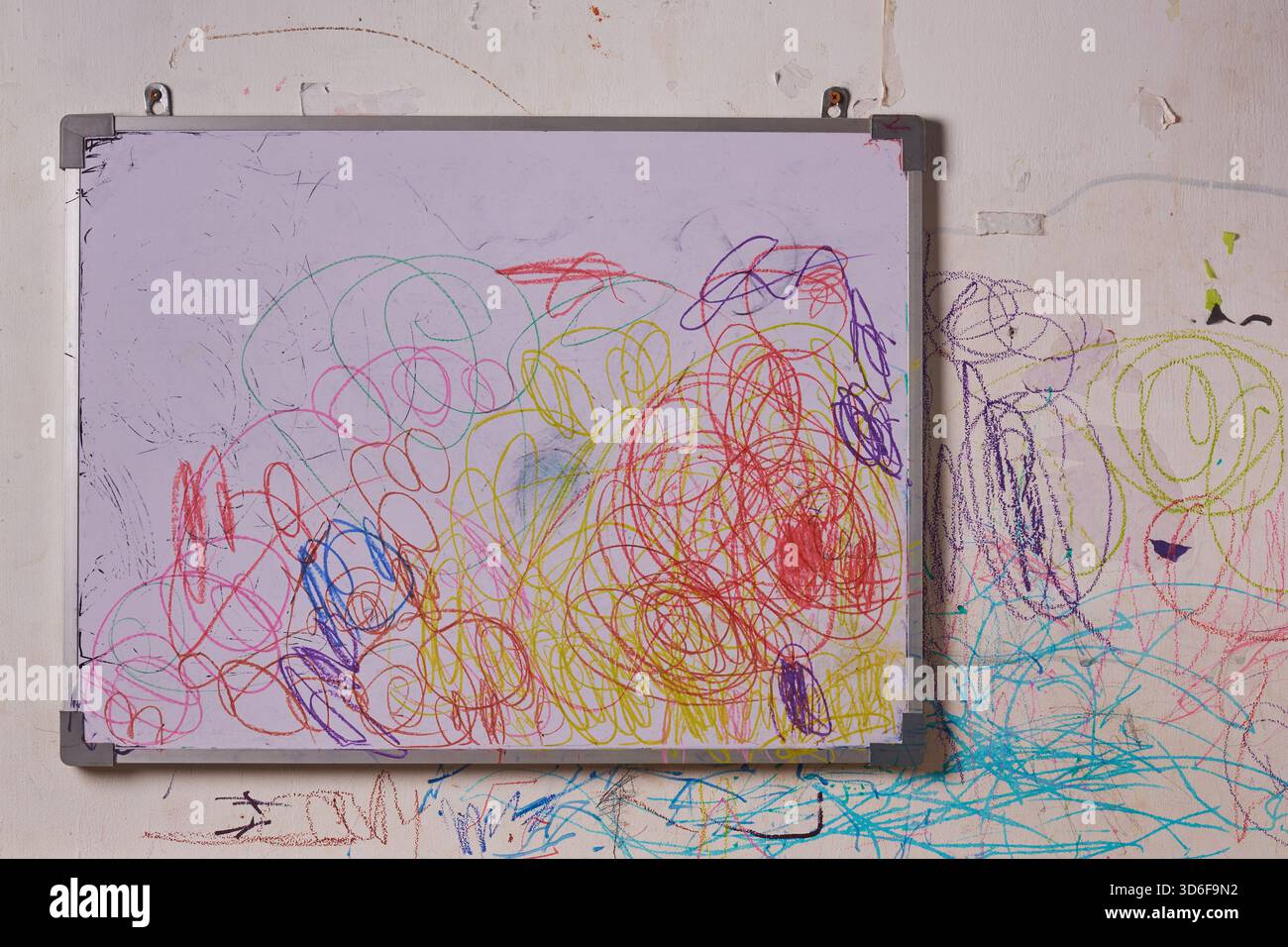 whiteboard covered in colorful scribbles and abstract marker drawings ...