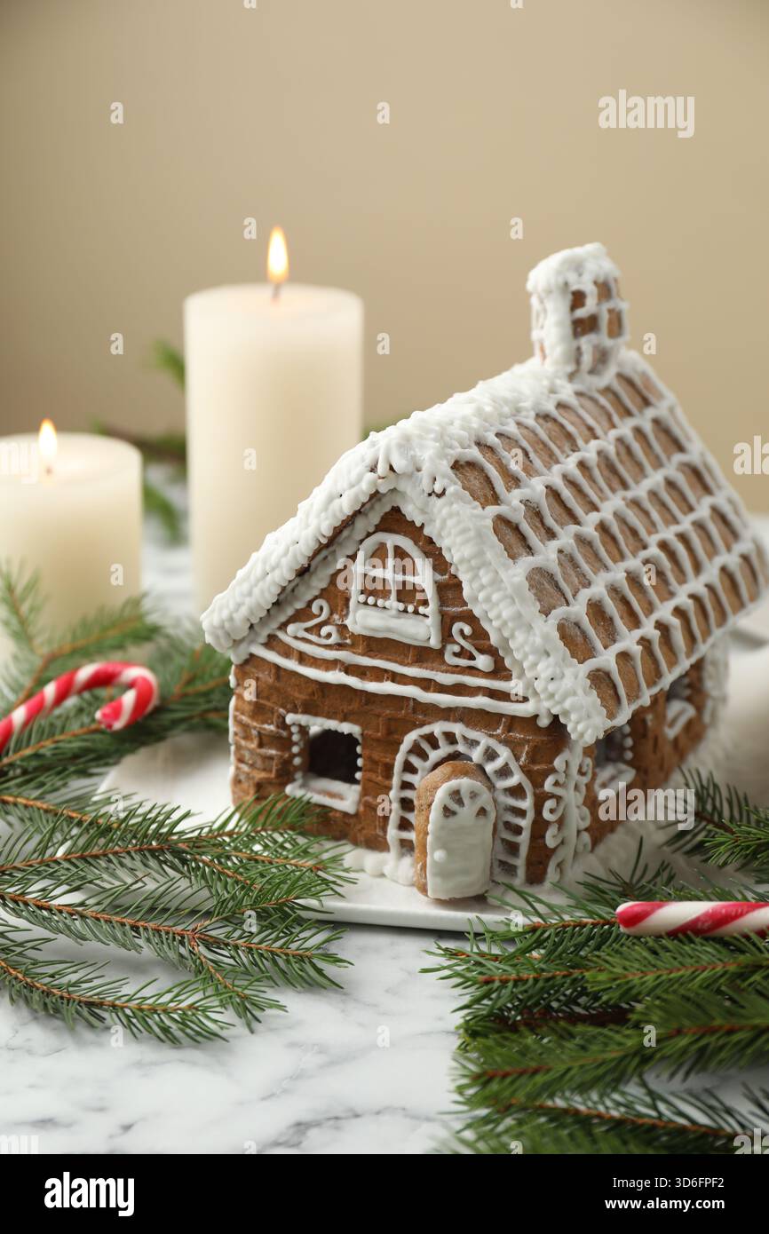 Gingerbread house, fir branches, burning candles and candy canes ...