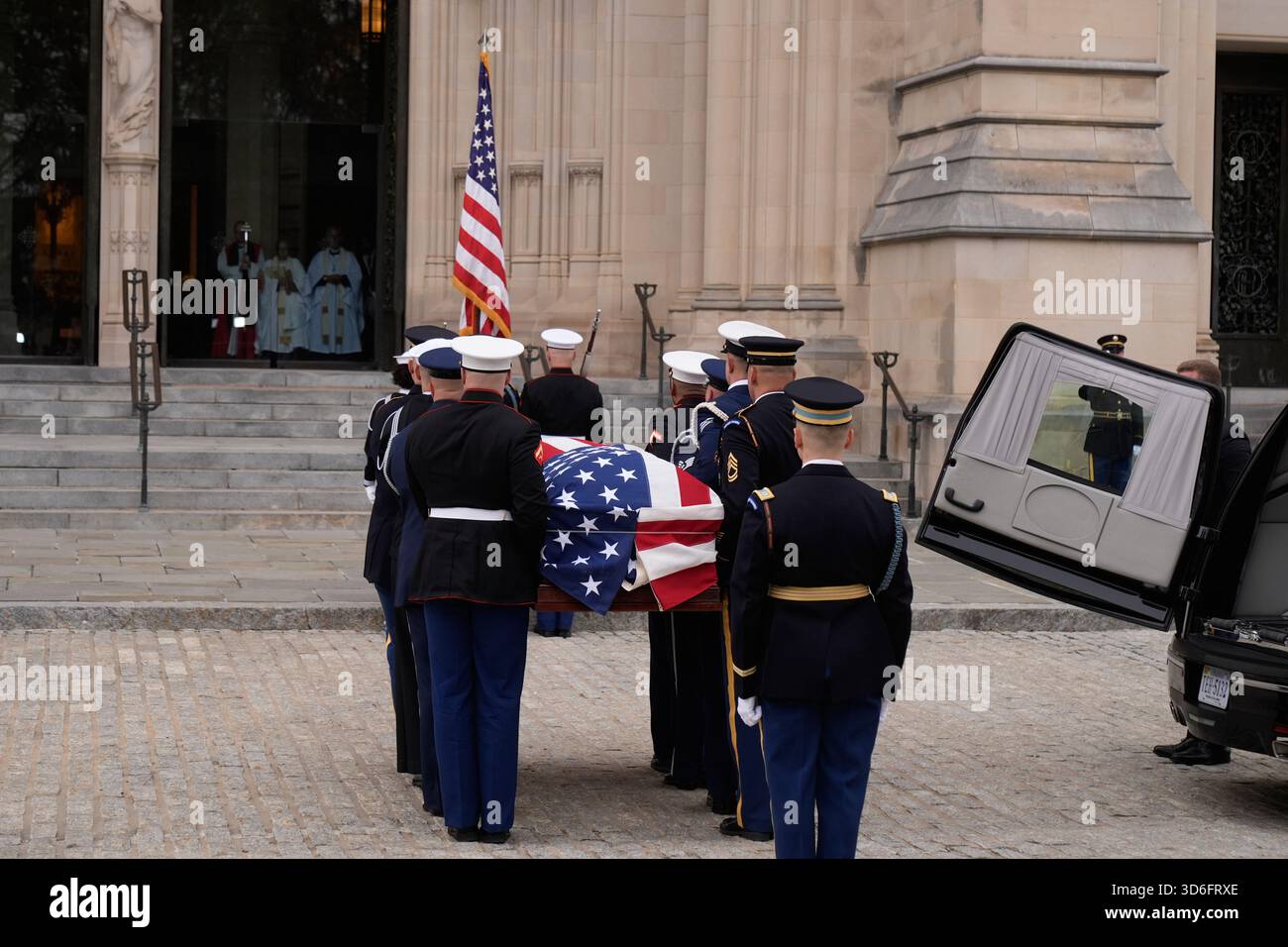 A joint services body bearer team carries the flag-draped casket of ...