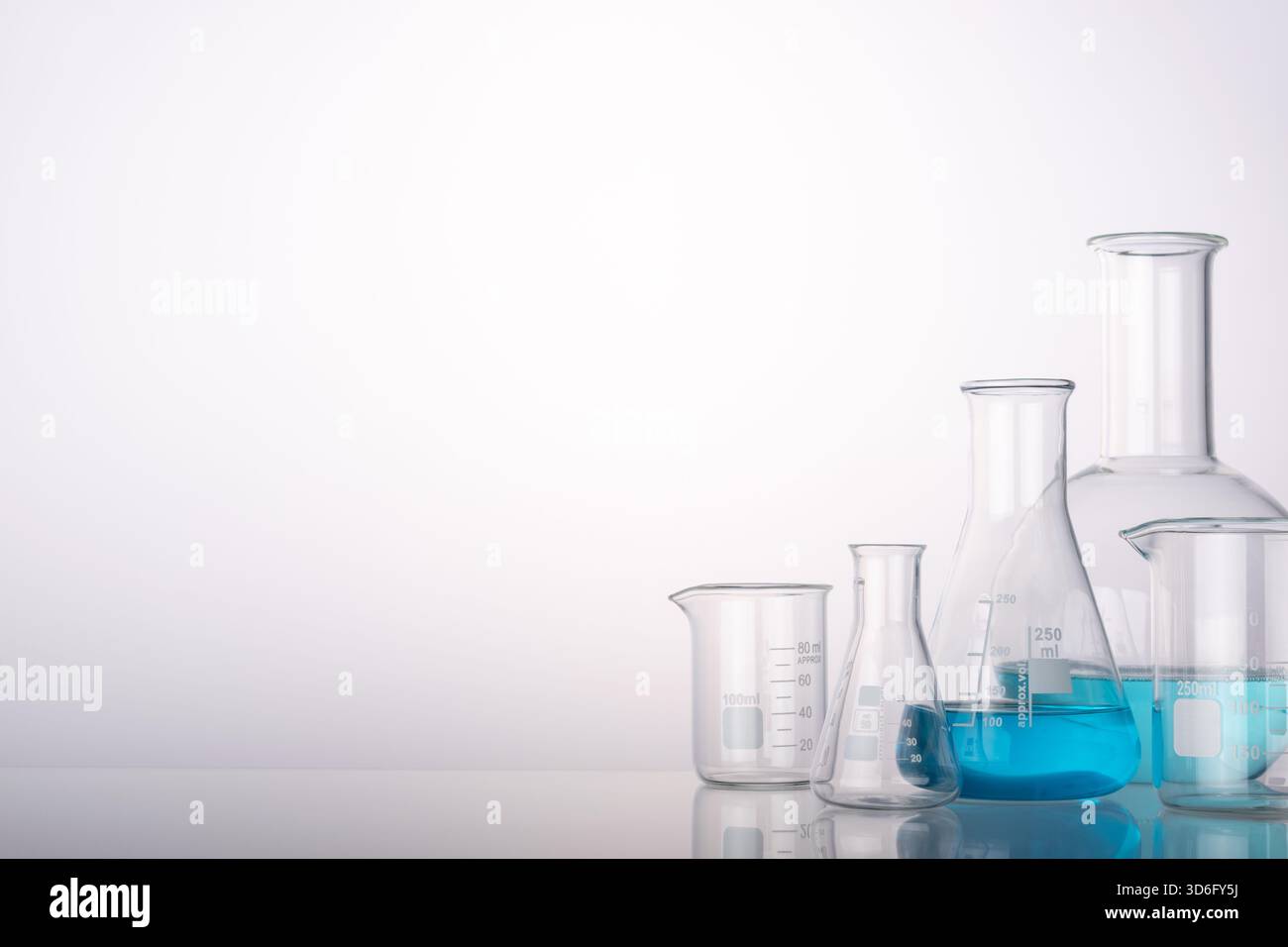 Laboratory equipment beakers and flasks with backlight in different ...