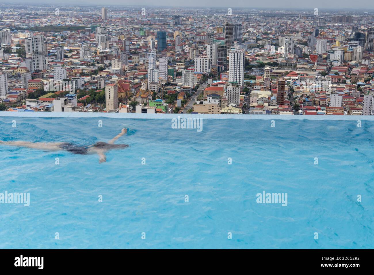 Kambodscha 2025 Phnom Penh - 19. November 2025: Eine Frau schwimmt in einem Infinity Pool auf ...