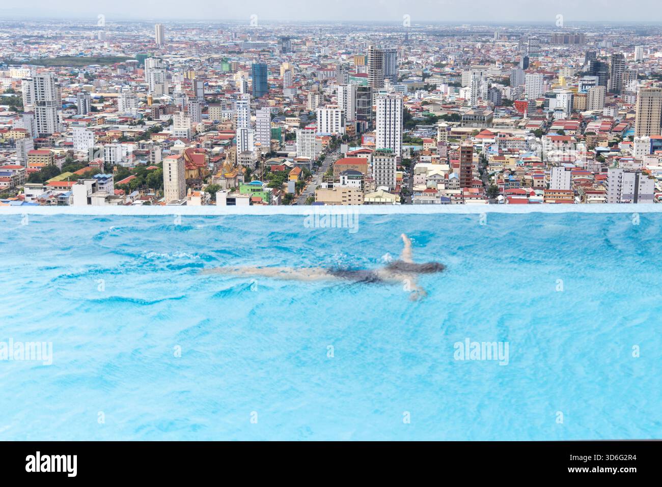 Kambodscha 2025 Phnom Penh - 19. November 2025: Eine Frau schwimmt in einem Infinity Pool auf ...