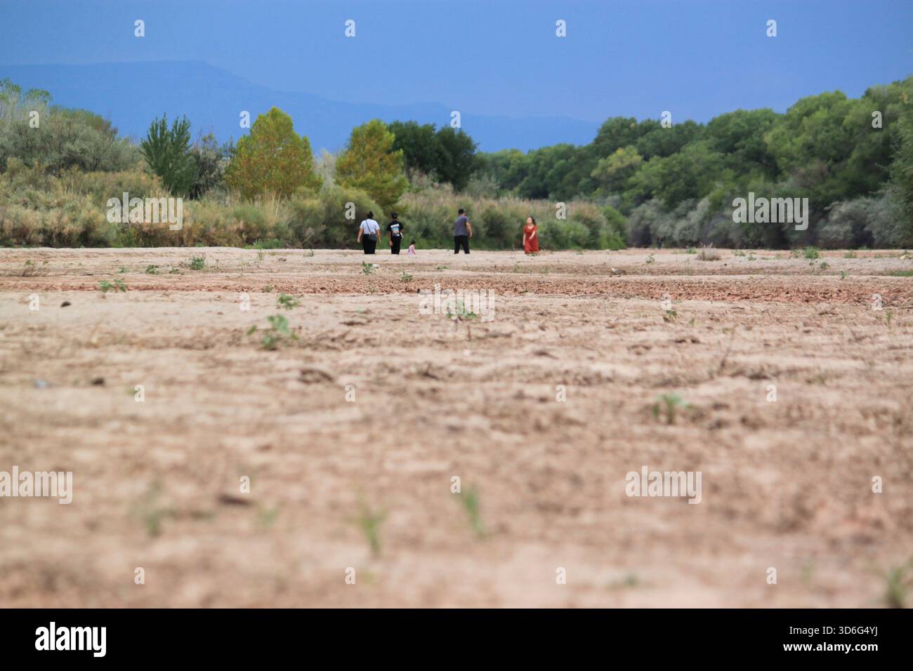 FILE - A family takes a walk in the Rio Grande's dry riverbed in ...